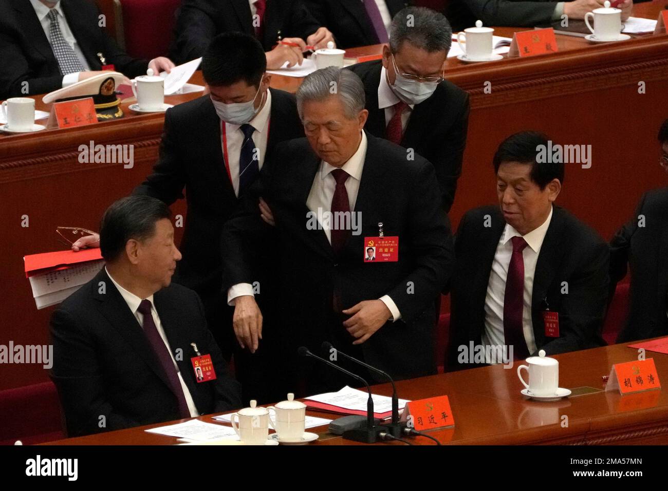 Former Chinese President Hu Jintao, center, is helped during the ...
