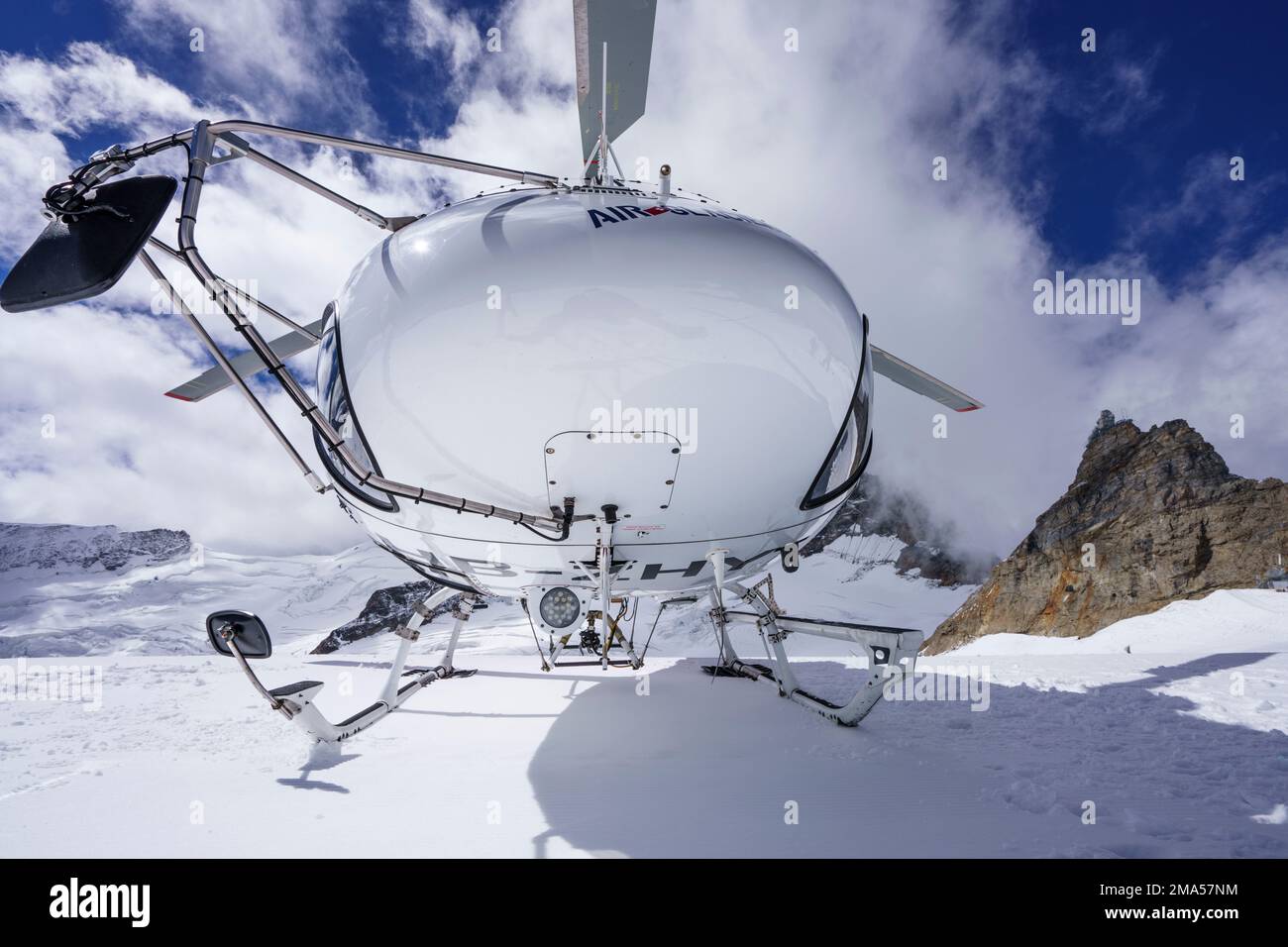 Swiss helicopter stands on Aletsch Glacier at the Jungfrau Joch, Eiger ...