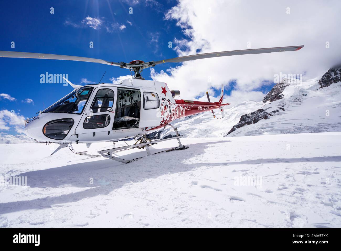 Swiss helicopter stands on Aletsch Glacier at the Jungfrau Joch, Eiger ...