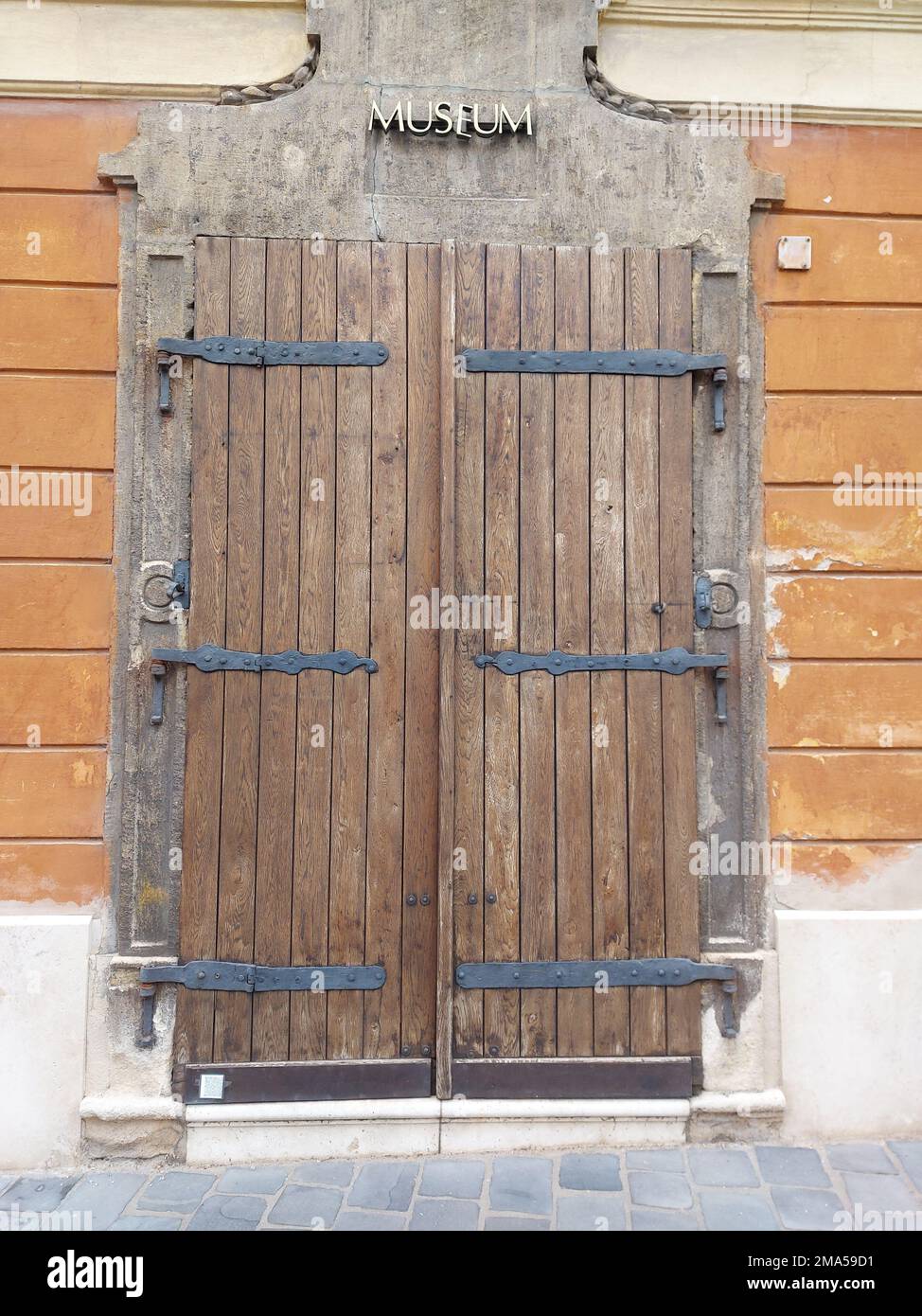 An old heavy massive wooden door with metal fittings and a decorative ...