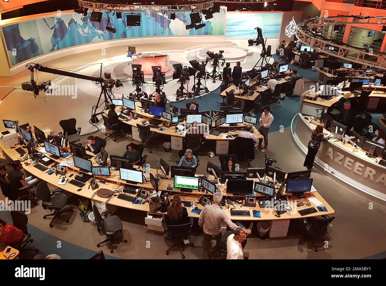 FILE - Al-Jazeera staff work at their TV station in Doha, Qatar ...