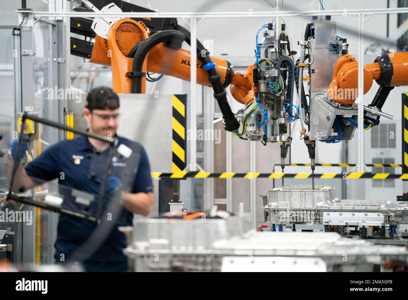 A robot and employee complete tasks in the battery assembly hall at the ...