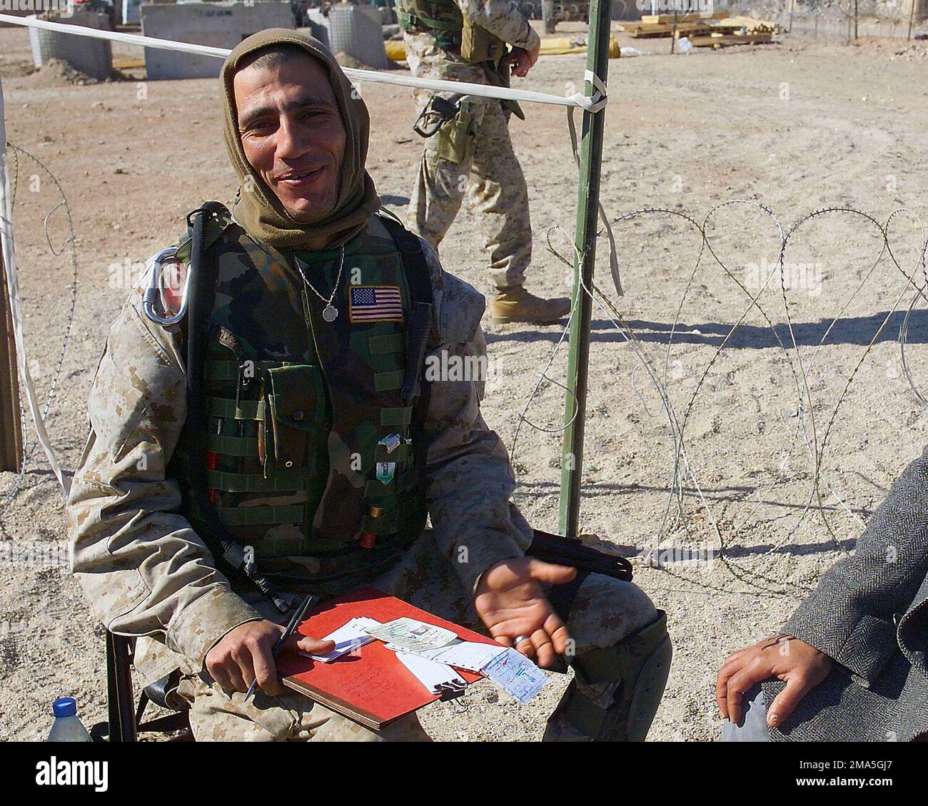 In Fallujah, Iraq (IRQ), an interpreter checks names on Humanitarian ...