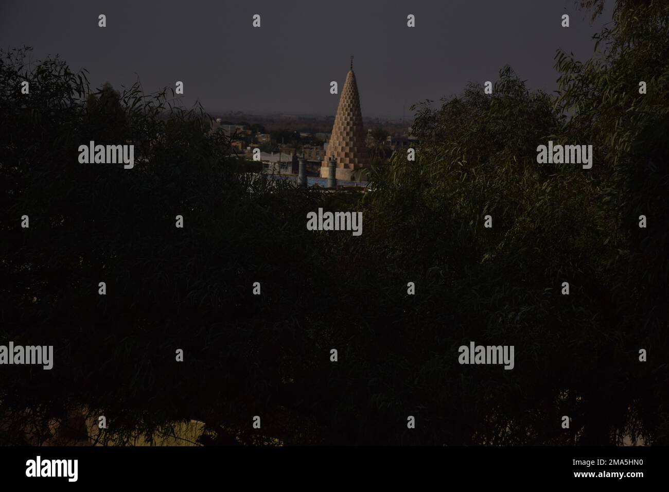 An aerial view of white tower behind growing trees in Israel in night ...