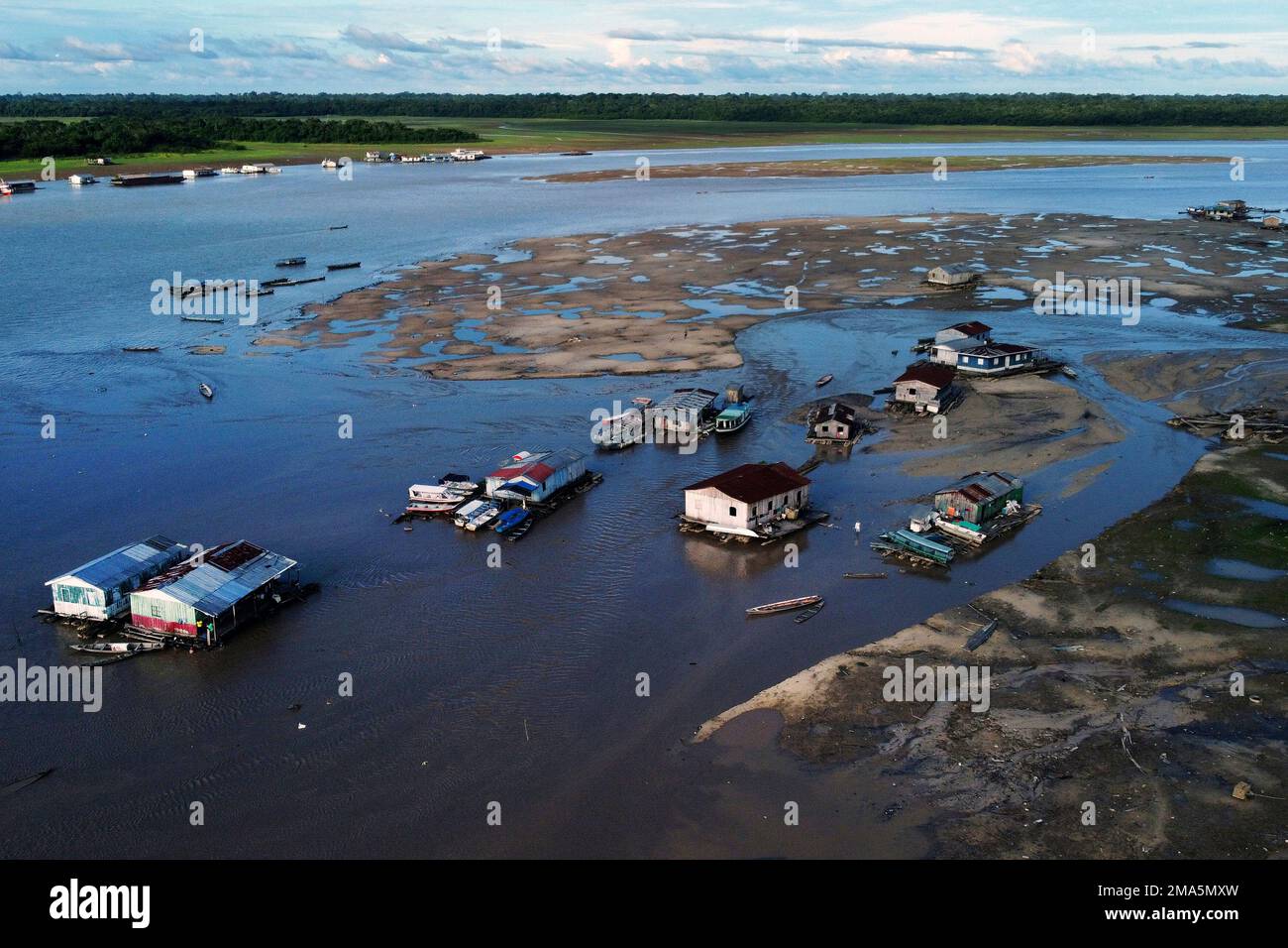 Houseboats sit amid drought-impacted land near the Solimões River, in ...