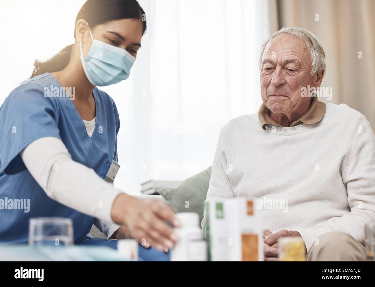 Youve got all the medication you need. a young female nurse helping a ...