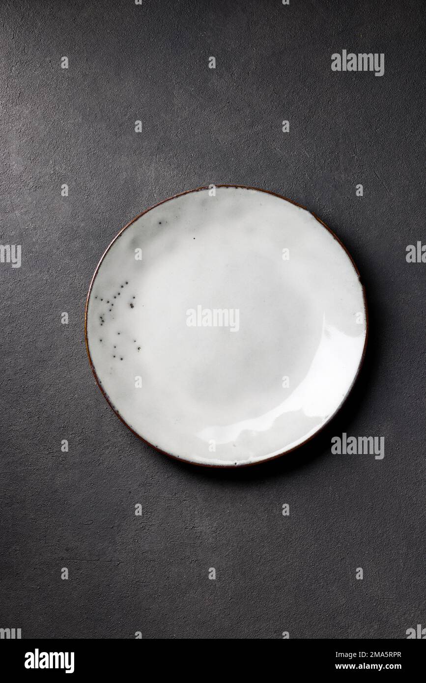empty white plate on black table, top view Stock Photo - Alamy