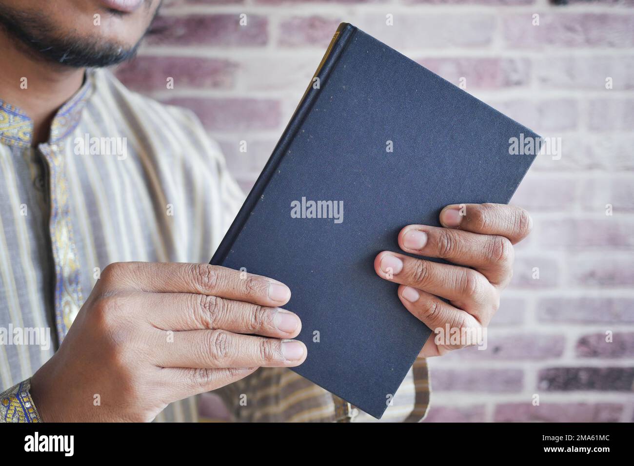 muslim man hand holding Holy book Quran with copy space Stock Photo - Alamy
