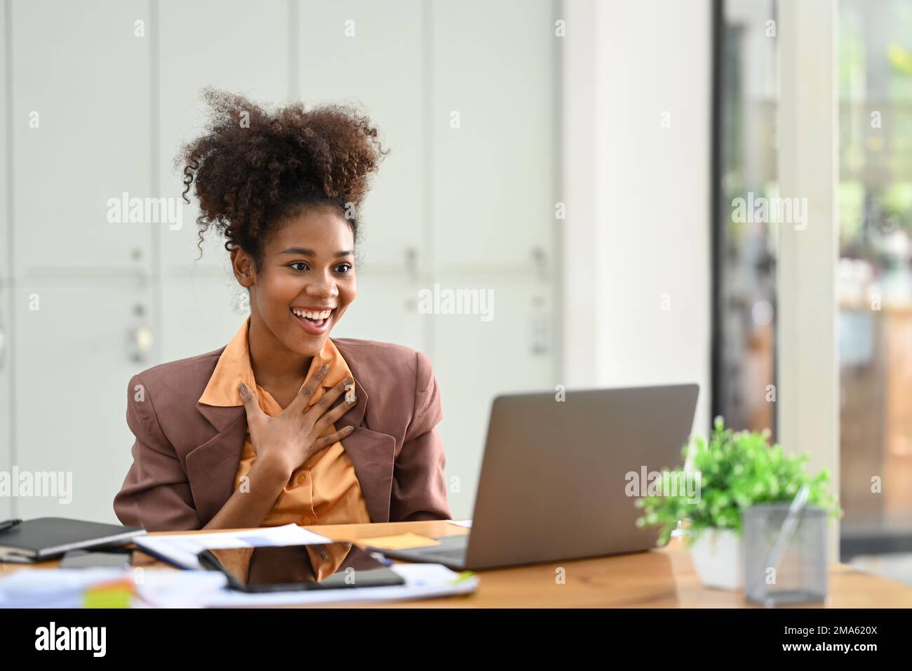 Surprised African American woman looking on laptop screen, getting ...