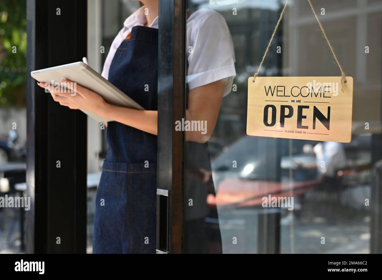 cropped image, Young Asian female barista or coffee shop owner in apron ...