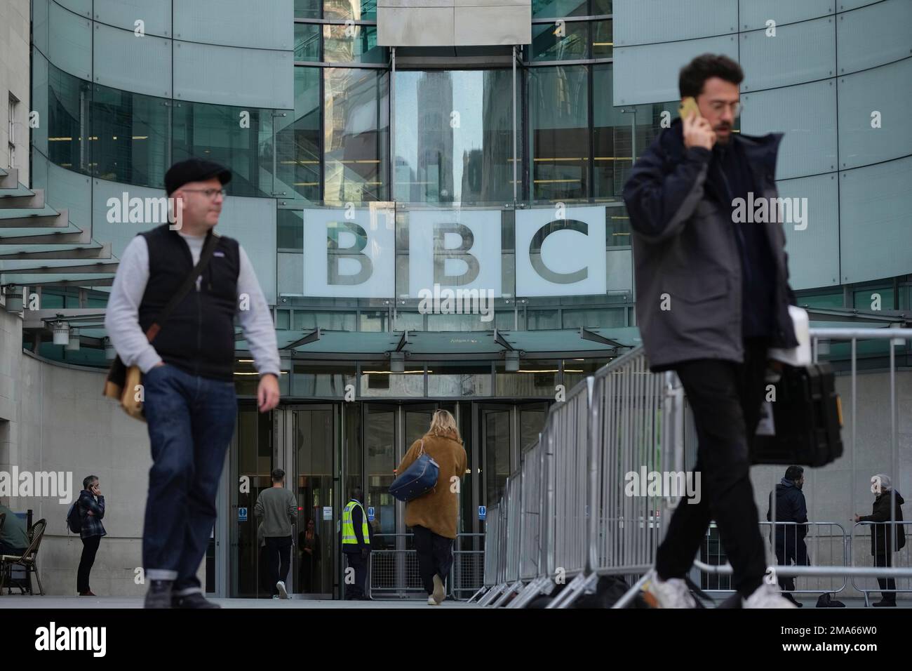 People walk past the BBC Headquarters in London, Tuesday, Oct. 18, 2022 ...