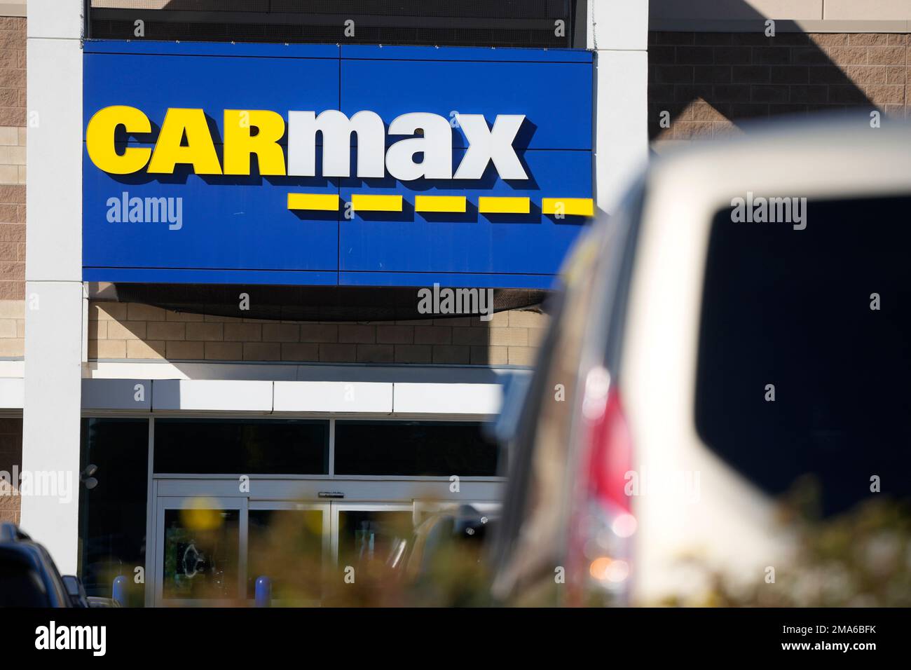 The company logo hangs on a sign over the showroom doors of a Car Max ...