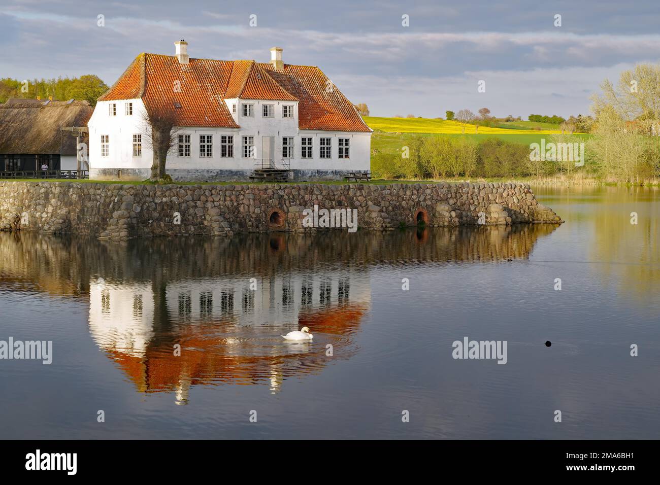 Manor house reflected in the water of a lake, small island, Soeby ...