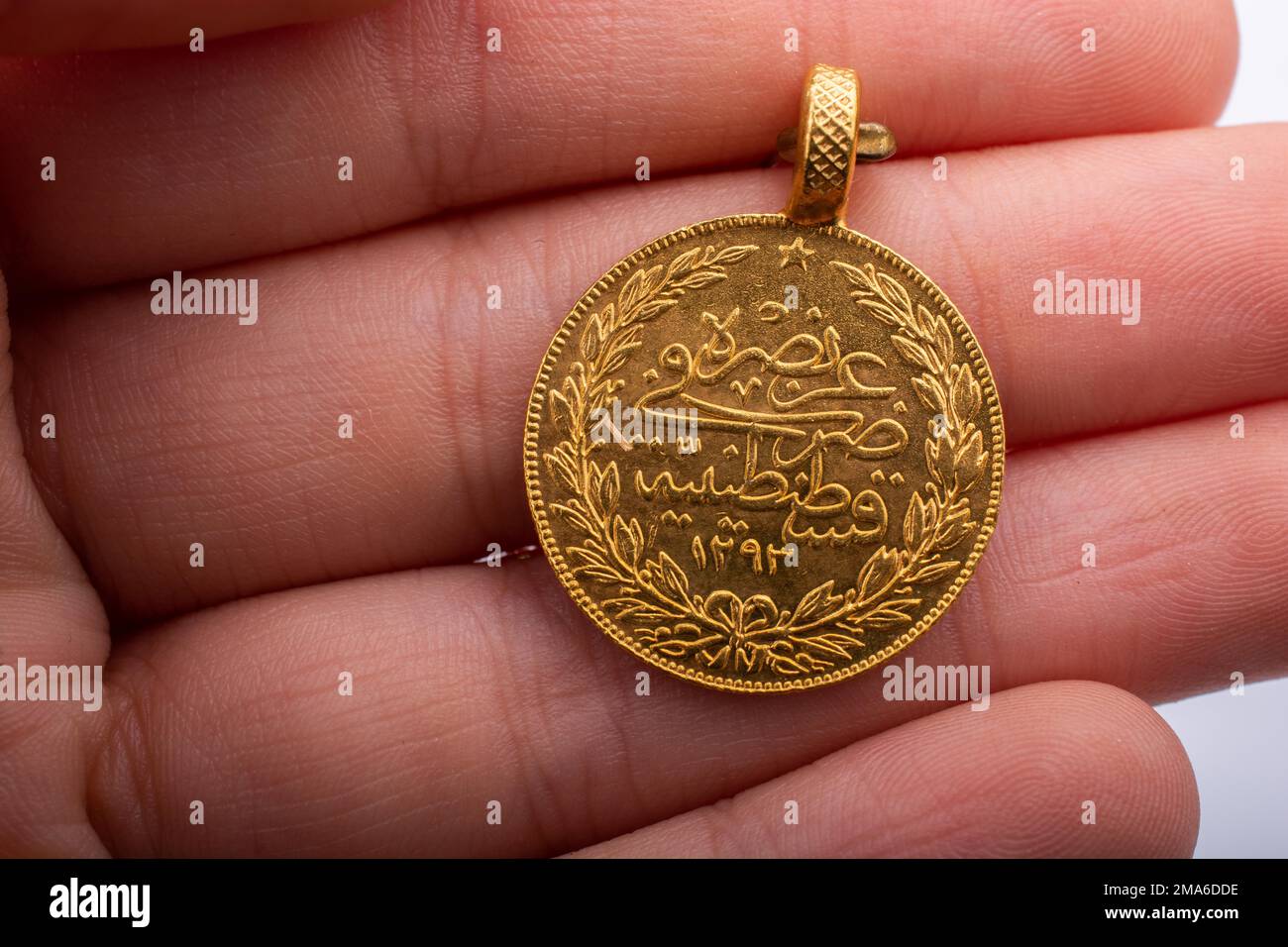 Turkish Ottoman style gold coin in hand on white background Stock Photo ...