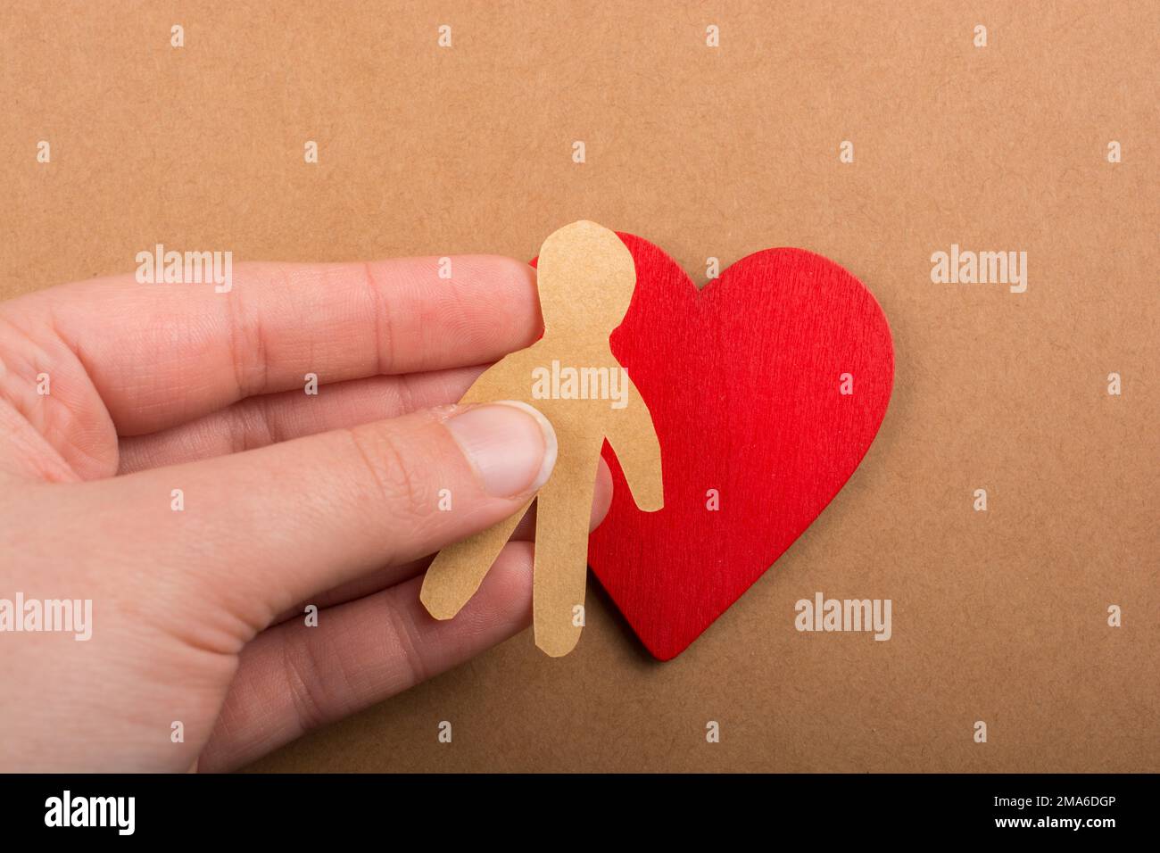 Man shape cut out of paper in hand in the view Stock Photo - Alamy