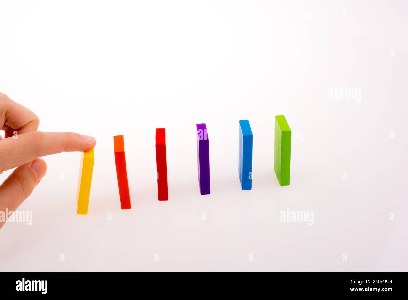 Hand playing with colored domino on white background Stock Photo - Alamy