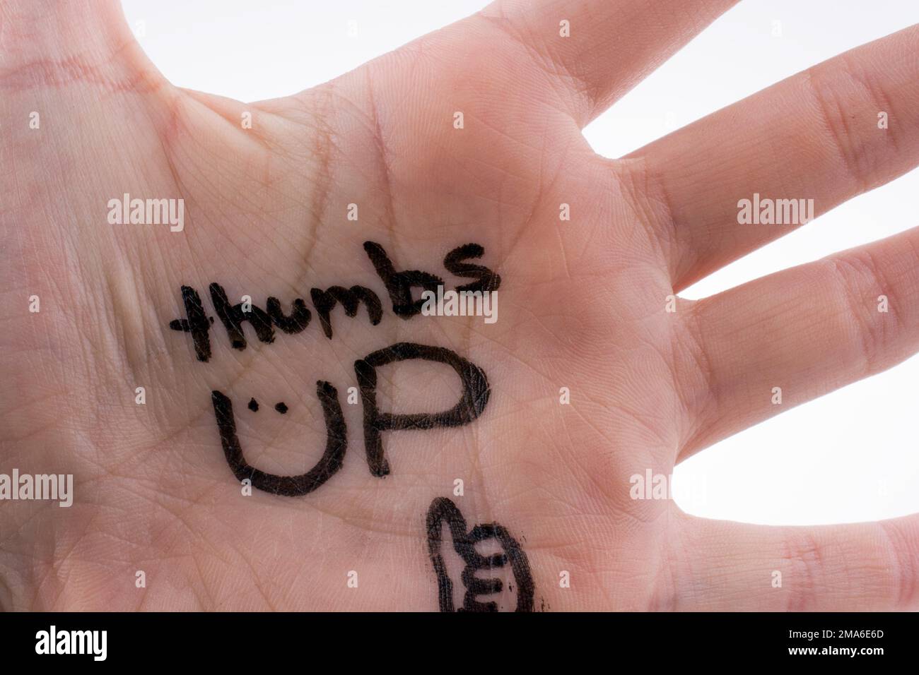 Thumbs up written on hand palm on a white background Stock Photo - Alamy