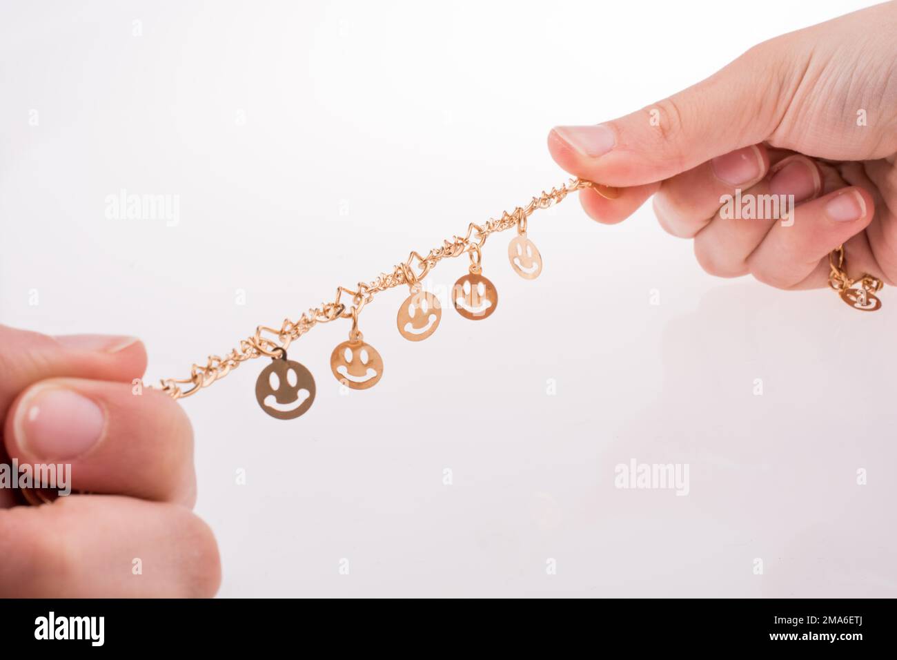 Golden color smileys arrayed on a chain in hand Stock Photo - Alamy