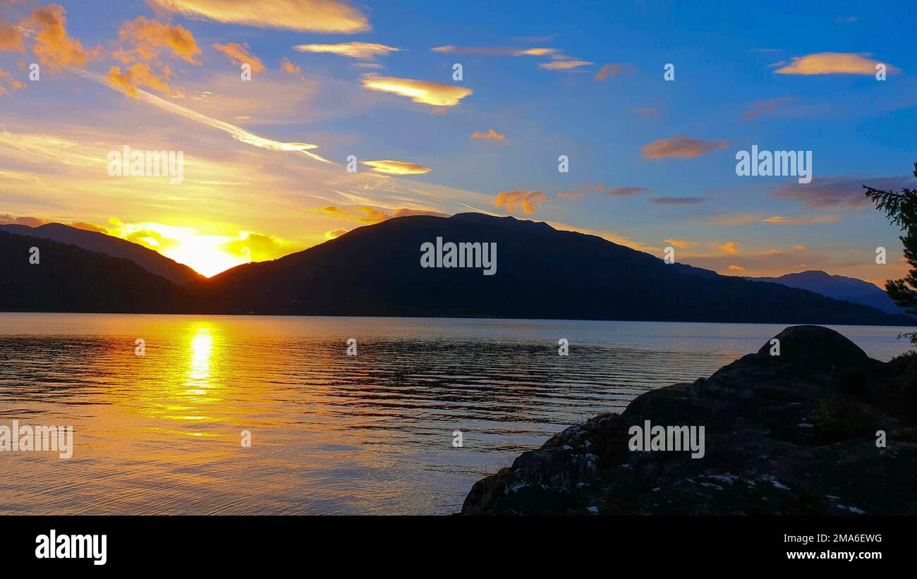 A beautiful view looking across Loch Lomond with sunset and mounts from ...