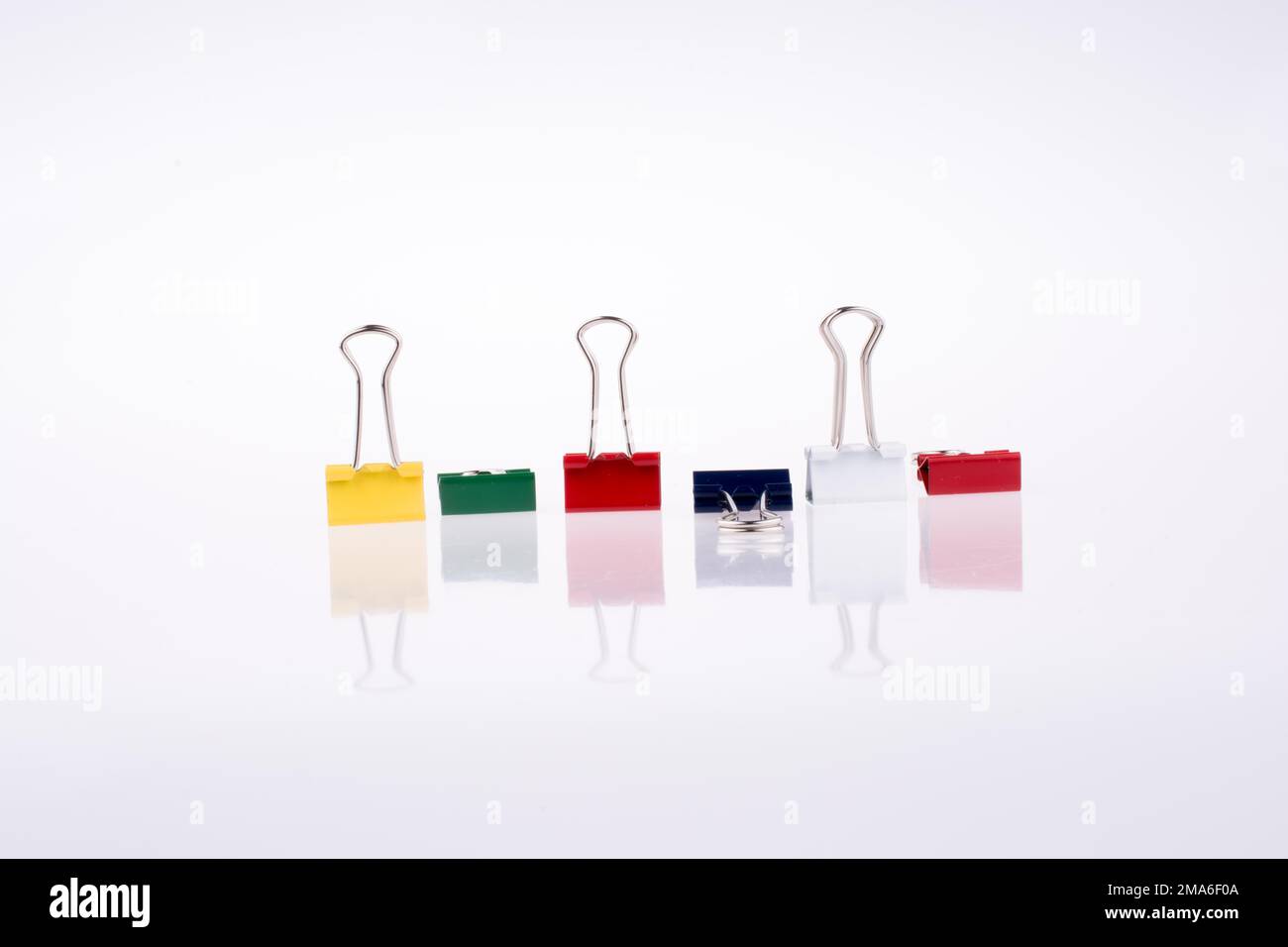 Colored paper clips on a white background Stock Photo - Alamy