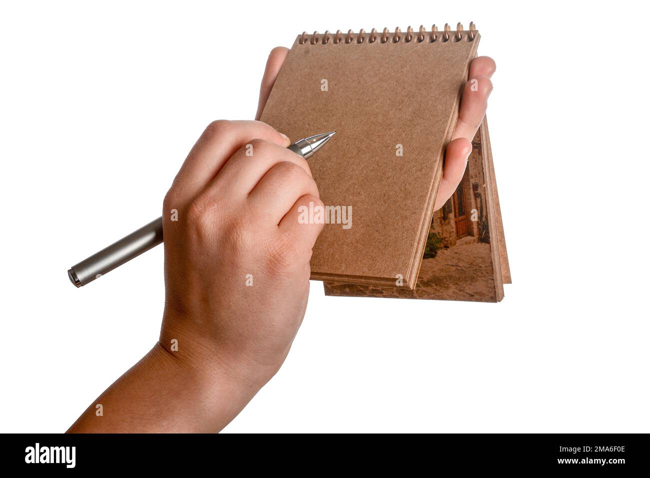Spiral brown notebook and a pen in child hand on a white background ...