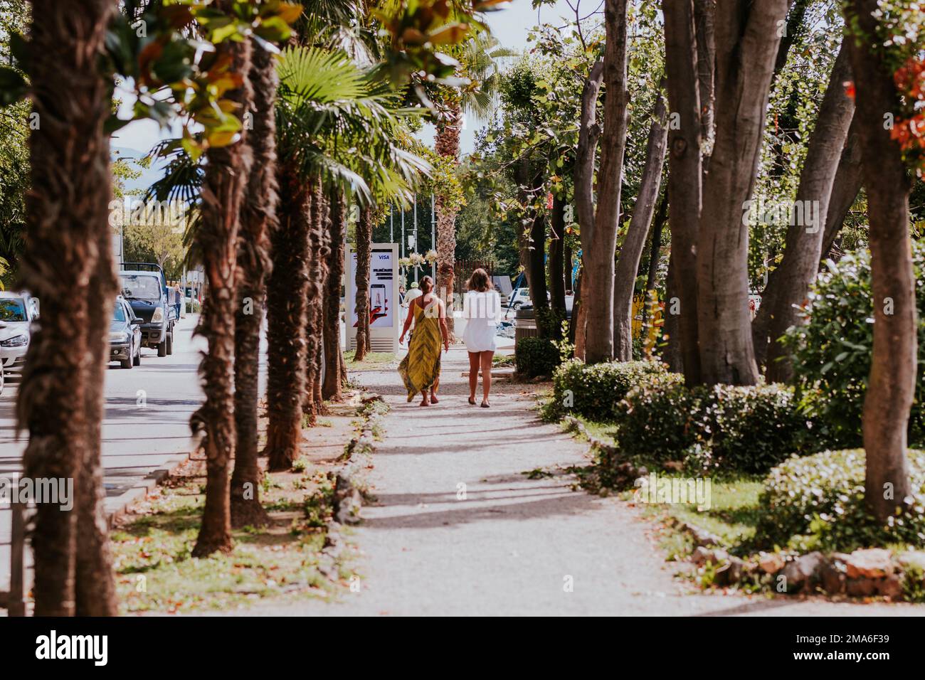 Mother and daughter walking alongside the beach on a tropical island ...
