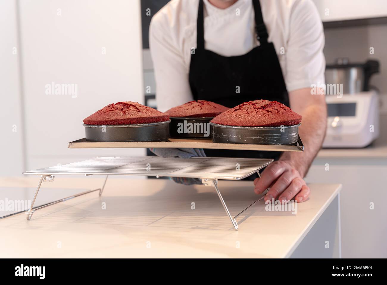 Hands of a man bakes a red velvet cake at home, sponge cake baked in ...