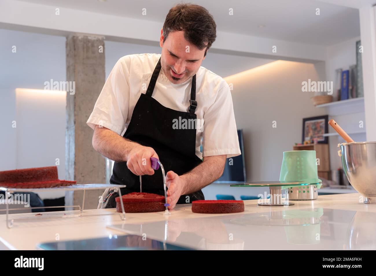 A challenger man bakes a red velvet cake at home, cutting the cake ...