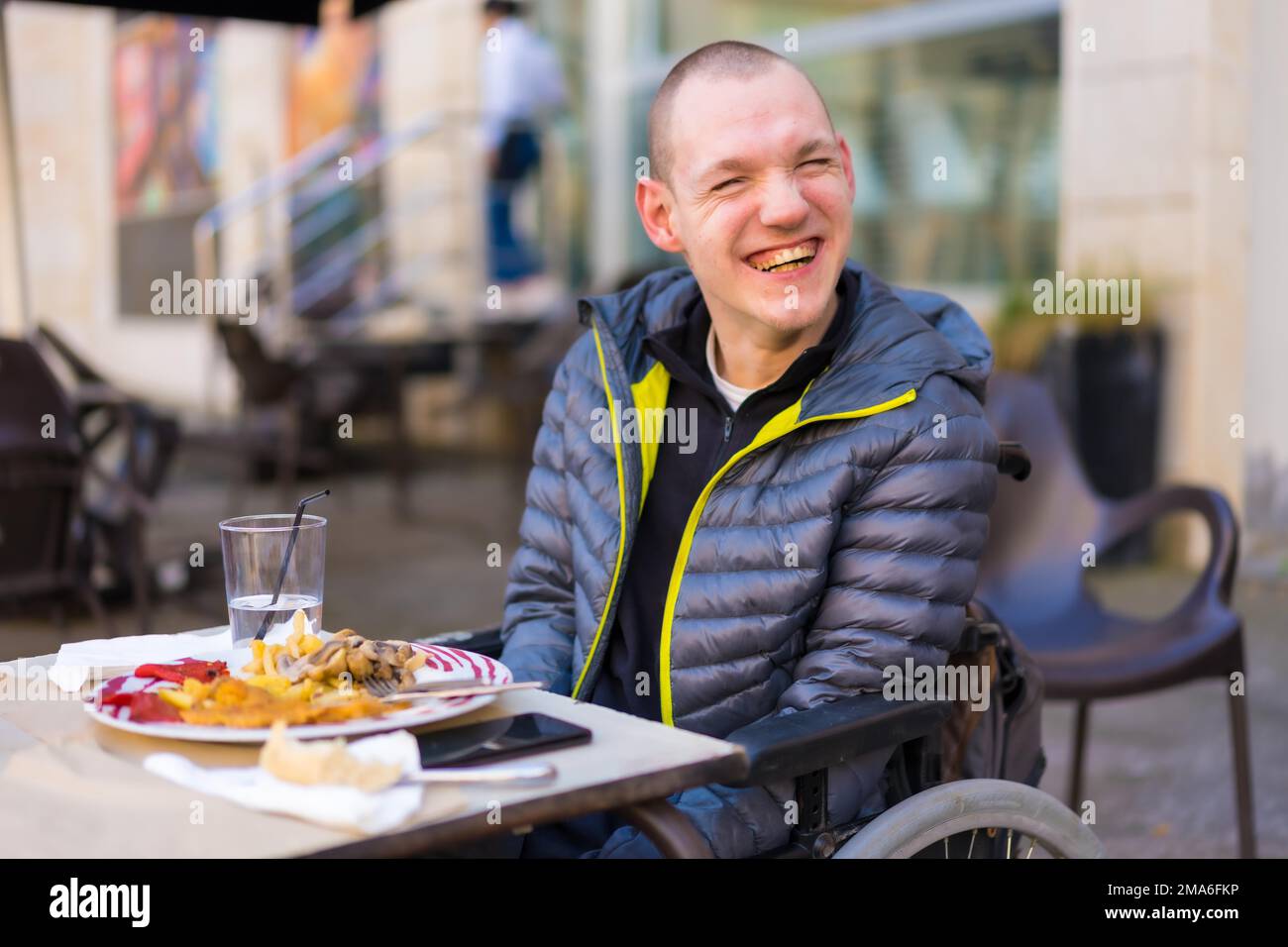 Portrait of a disabled person in a wheelchair in a restaurant smiling ...