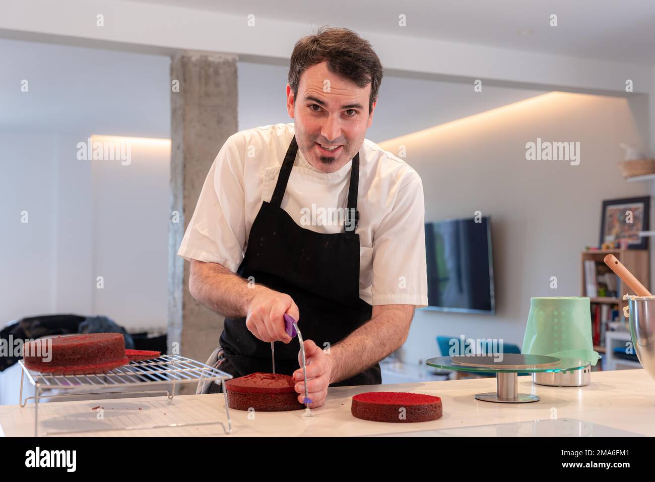 A challenger man bakes a red velvet cake at home, cutting the cake ...