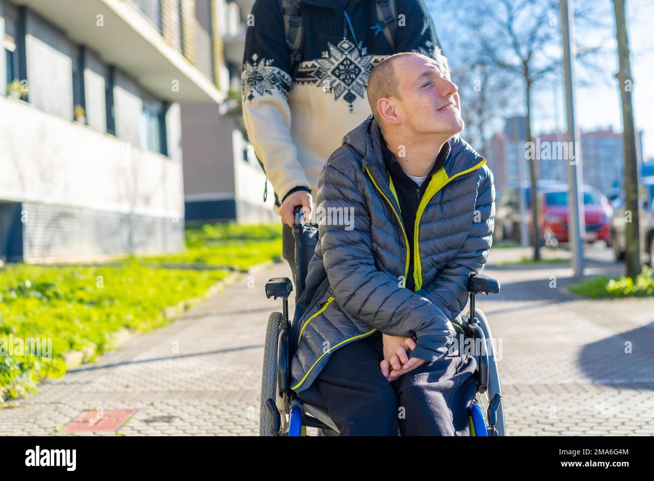 A disabled person enjoying walking on the street in a wheelchair ...