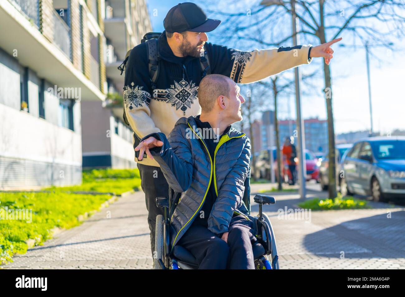 A person with a disability in a wheelchair with a friend walking around ...