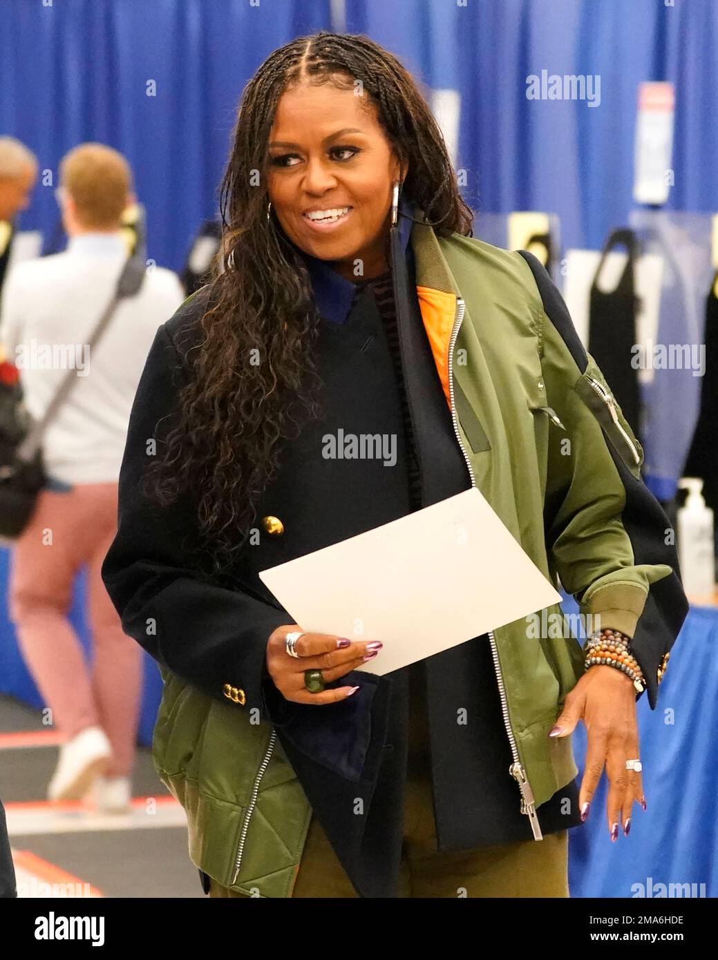 Former first lady Michelle Obama heads to a voting machine to cast her ...