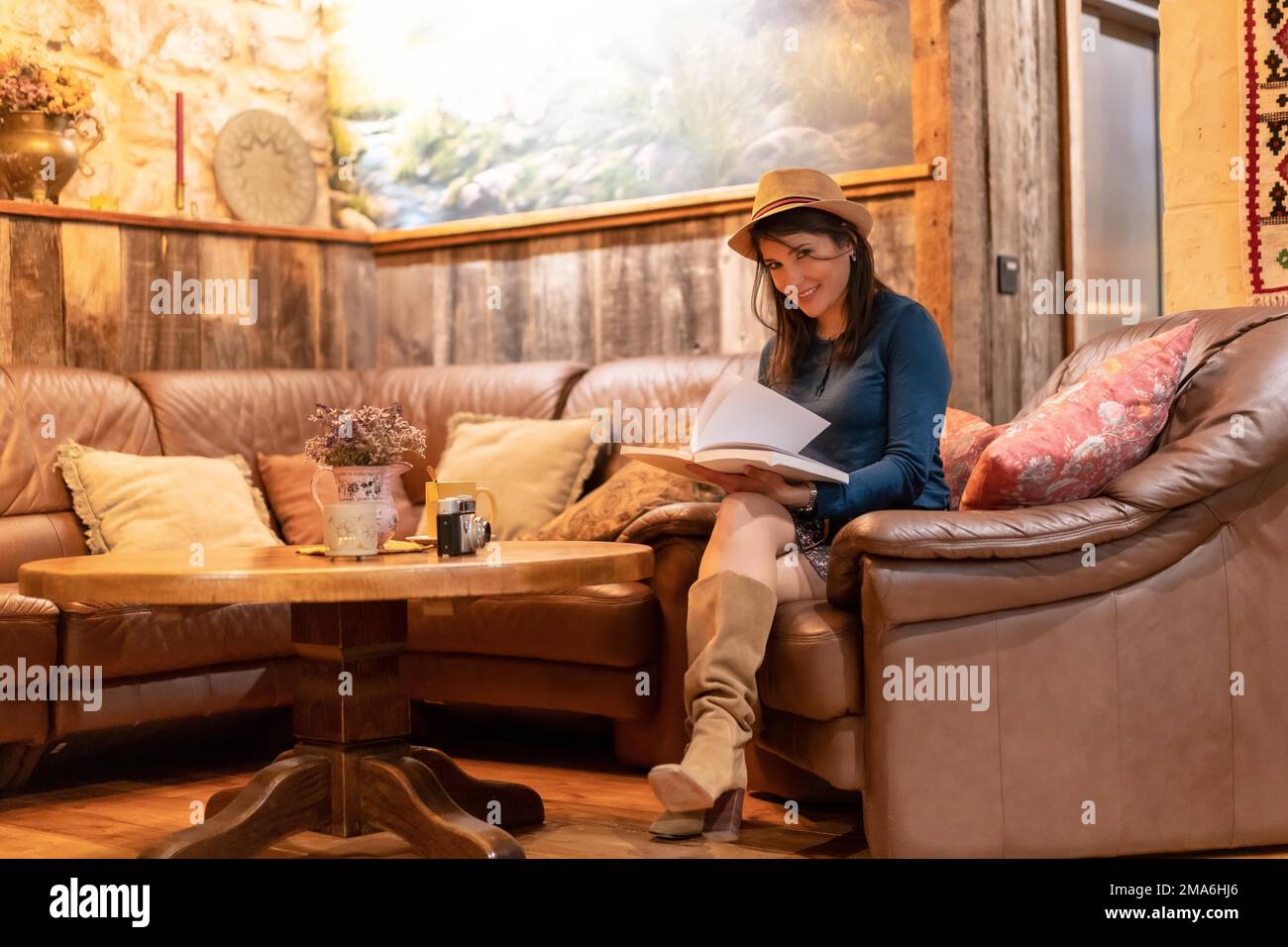 A pretty tourist with a hat and with a photo camera drinking tea in a ...