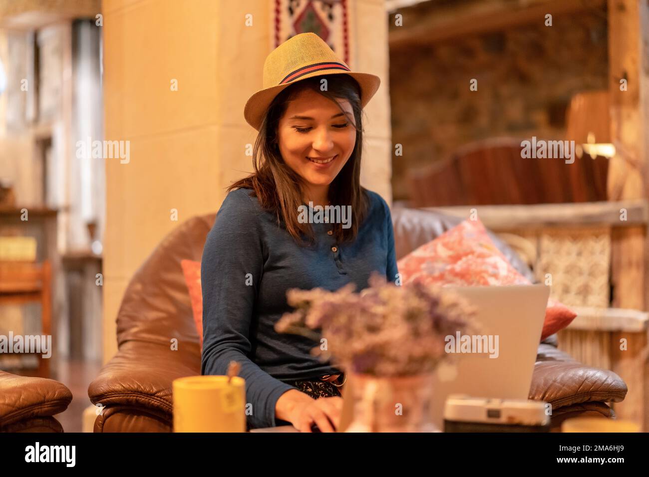 A pretty tourist in a hat and with a photo camera drinking tea in a ...