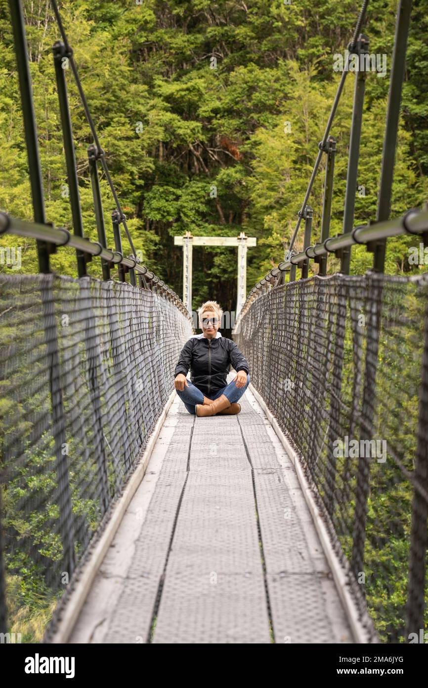Front view to the white adult smiling Woman sitting on the Suspension ...