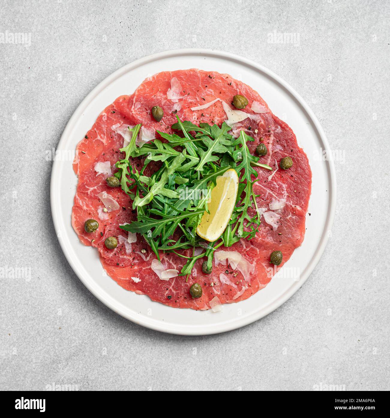 Beef carpaccio with capers, arugula and parmesan Stock Photo - Alamy