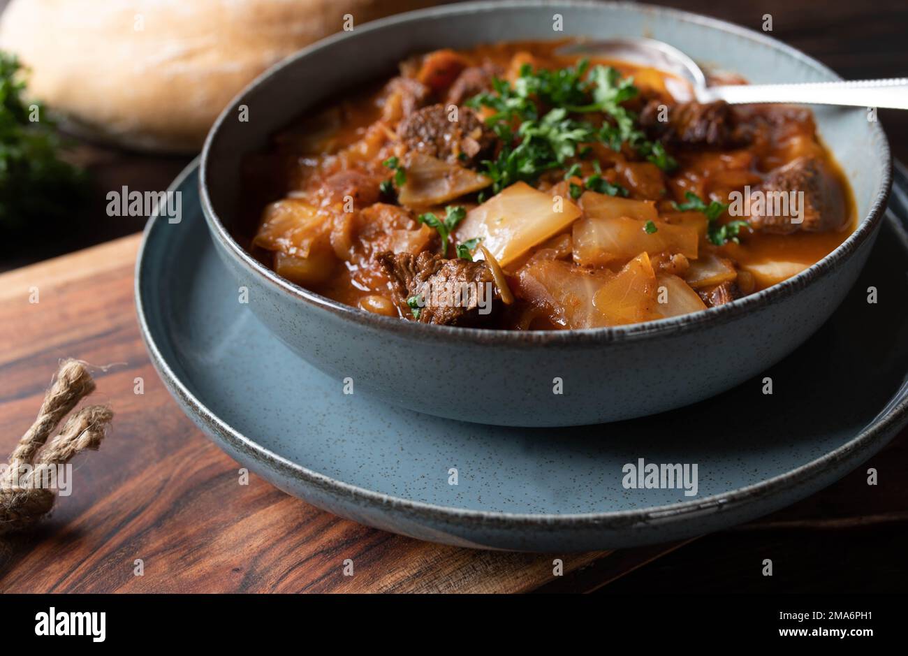 Homemade beef stew with cabbage and vegetables. Served in a grey bowl ...
