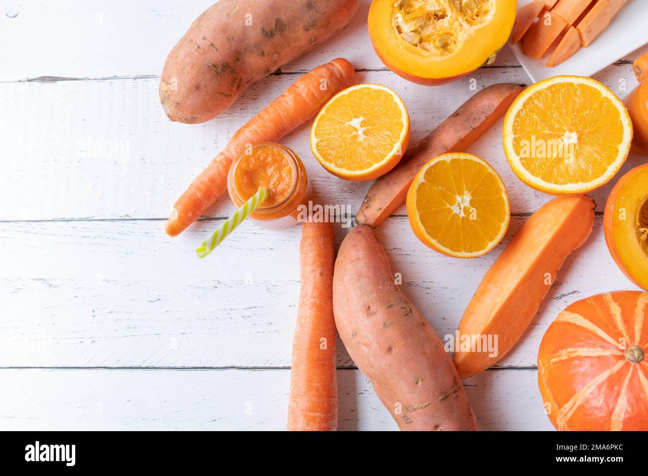 Orange colored vegetables and fruits on white background. Flat lay with ...