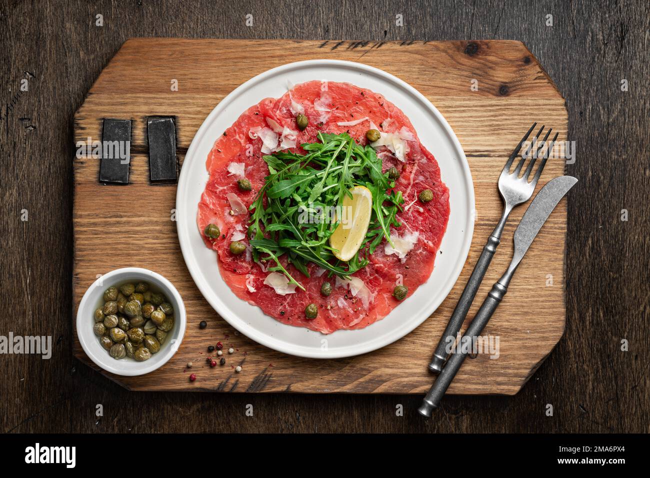 Beef carpaccio with capers, arugula and parmesan Stock Photo - Alamy