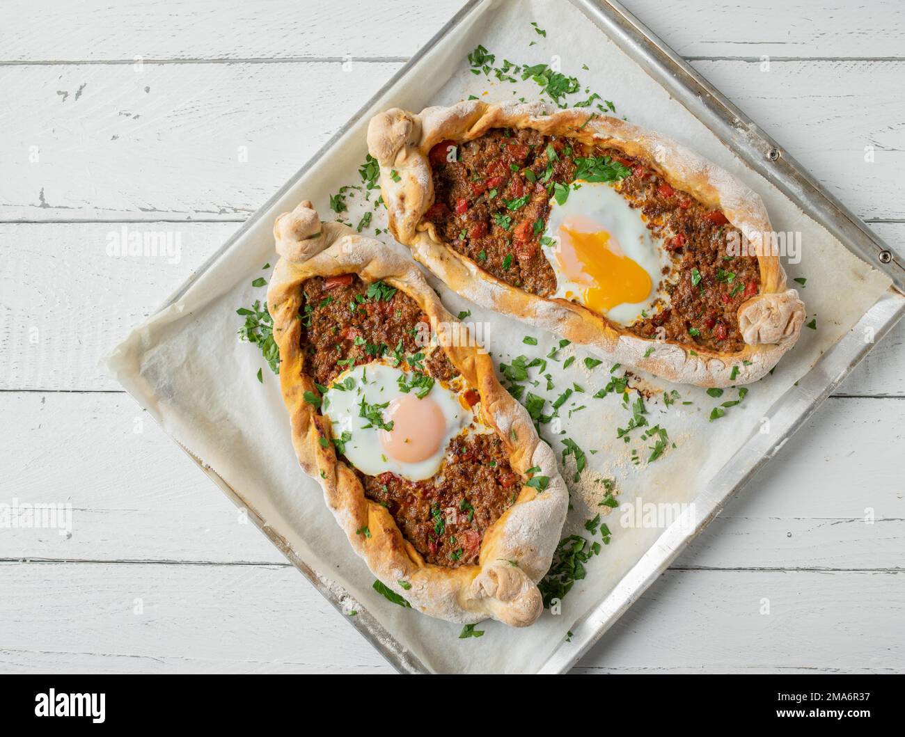 Turkish Pide with spicy minced meat filling and poached egg topping on ...