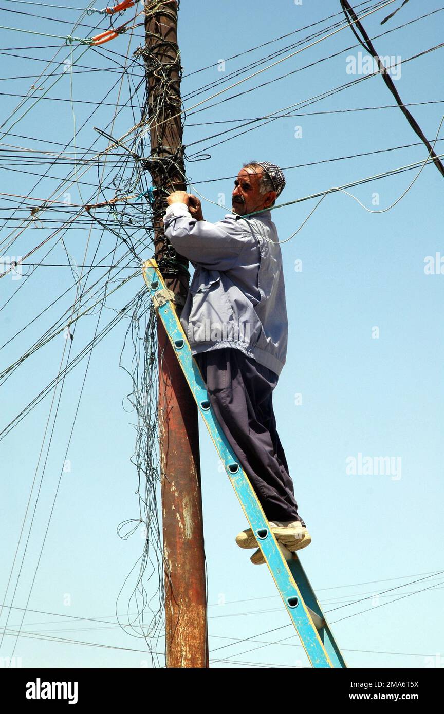 Candid shot of an Iraqi man risking his life to pirate electricity in ...