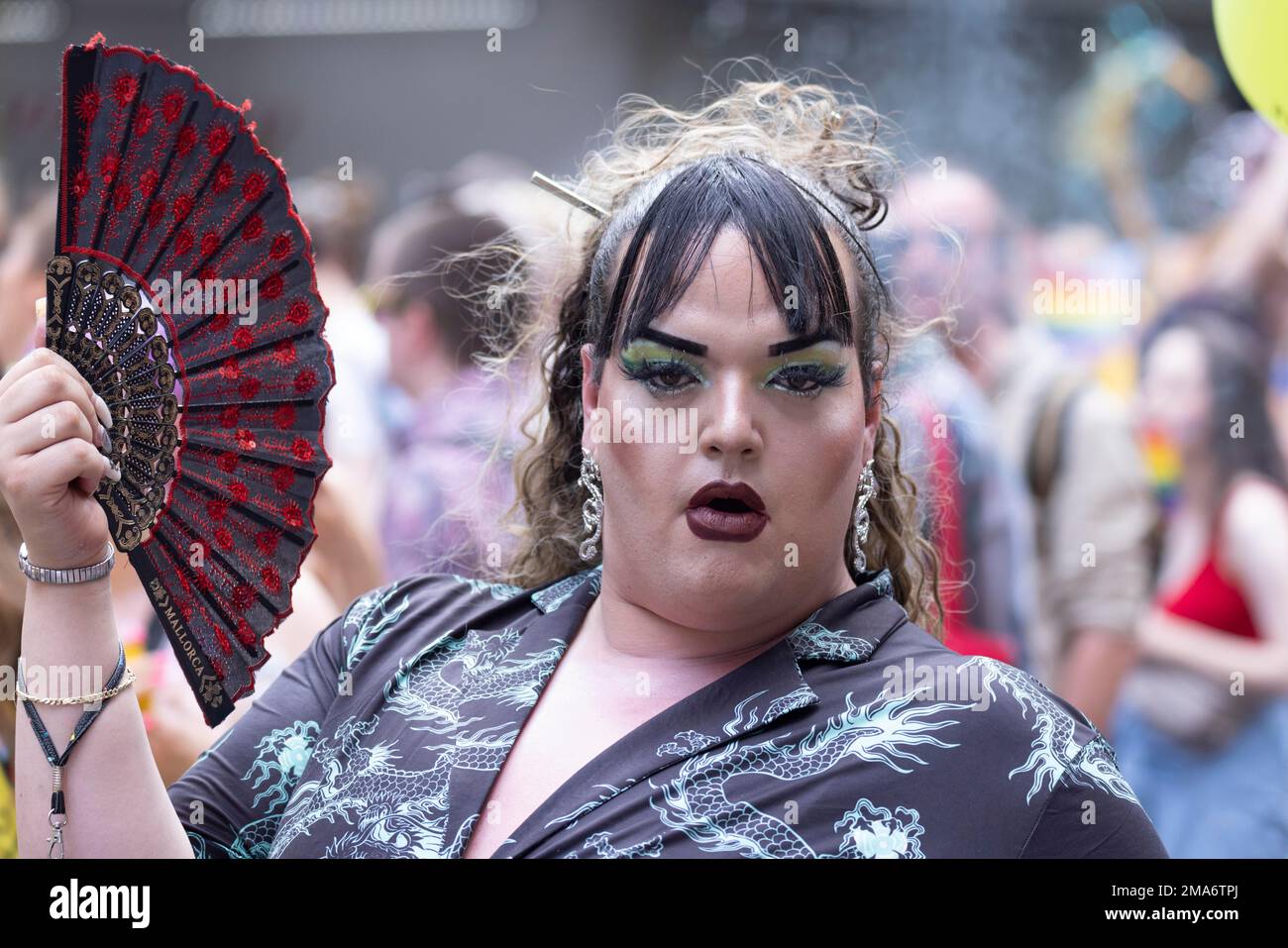 Made-up transvestite with fan at the CSD parade, Cologne, North Rhine ...