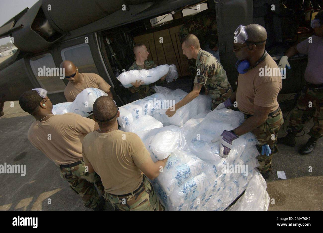 US Air Force (USAF) personnel load bags of ice on board a US Army (USA ...