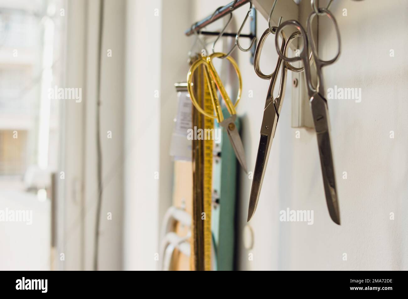 close up of stainless steel sewing scissors hanging on the shelf ...