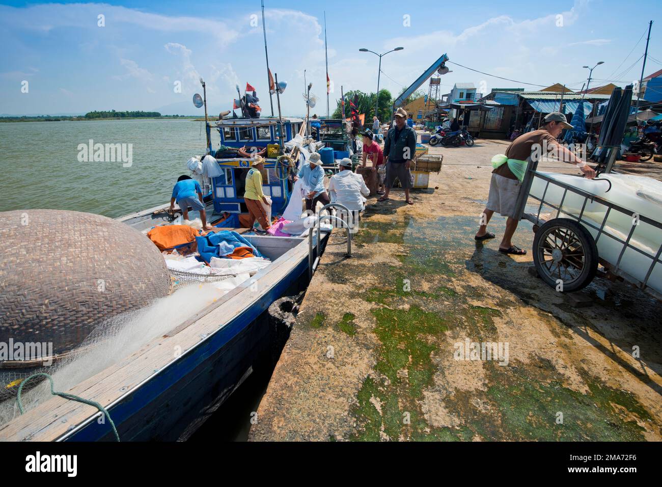 Small fishing pier on the Thu Bon River where a fishing boat is ...
