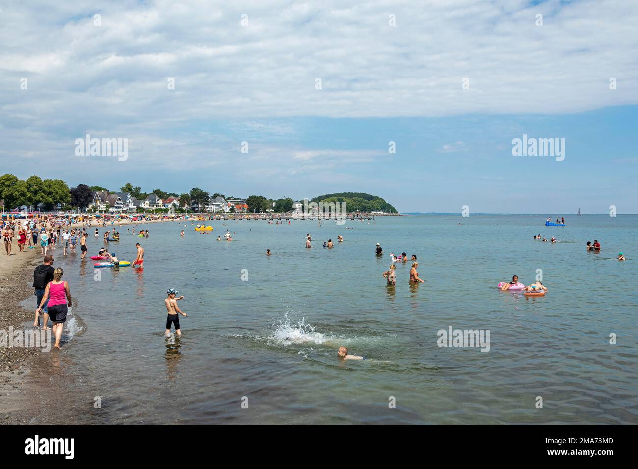 Beach, people bathing in the sea, houses on the shore, Travemuende ...