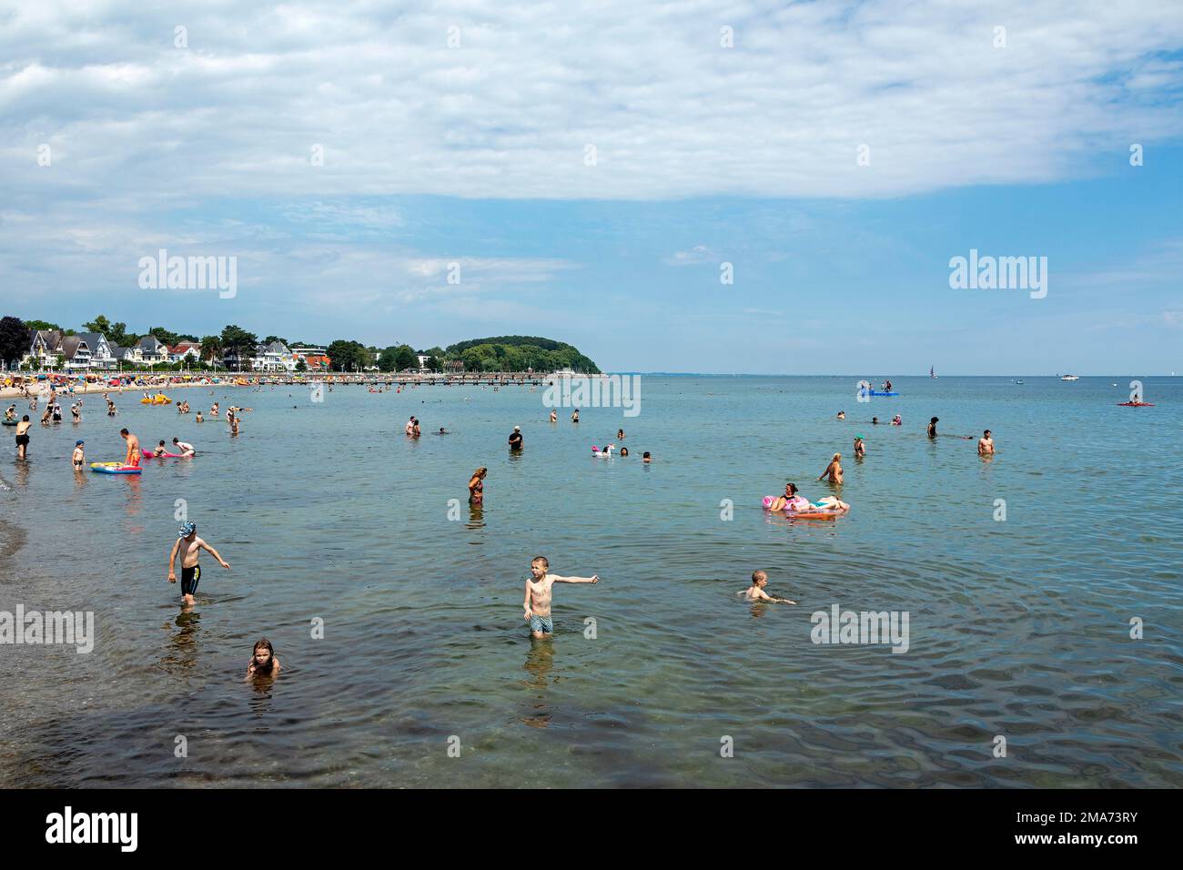Beach, people bathing in the sea, houses on the shore, Travemuende ...