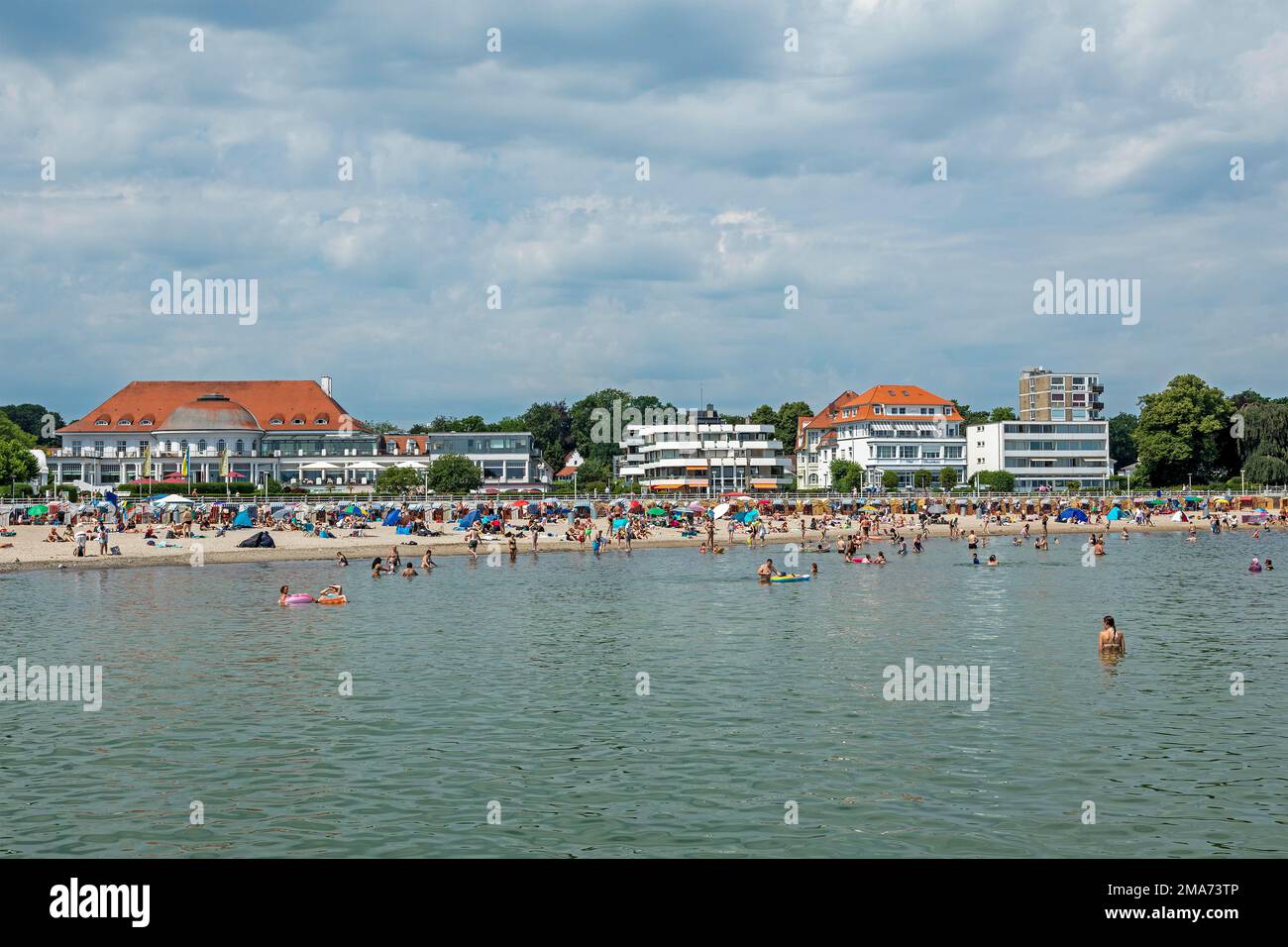 Beach, people bathing in the sea, houses on the shore, Travemuende ...