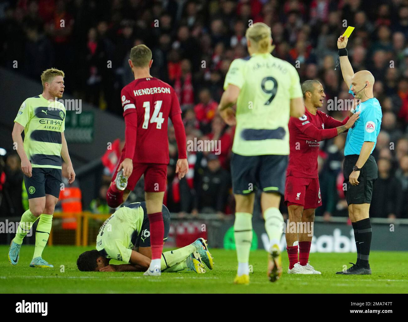 Referee Anthony Taylor, right, shows a yellow card to Liverpool's ...